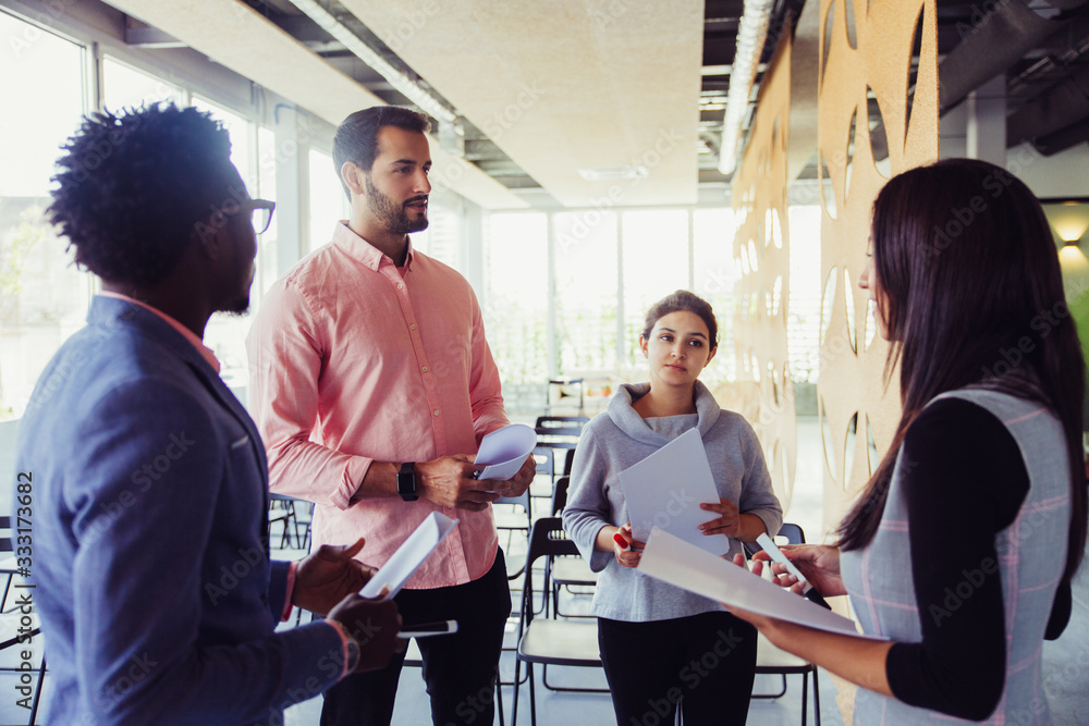 Multiethnic training group discussing their task. Young men and women ...
