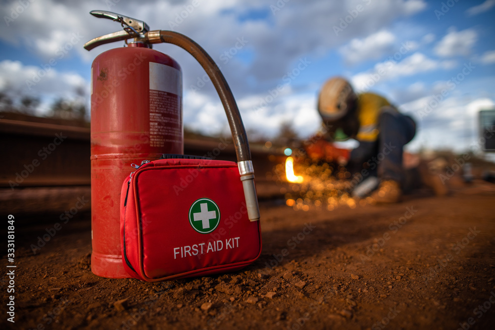 Safe workplace red First Aid Kit together with fire extinguisher are ...