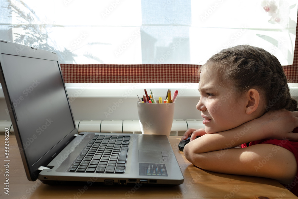 Caucasian preteen girl concentrated on her task with laptop. Concept of ...