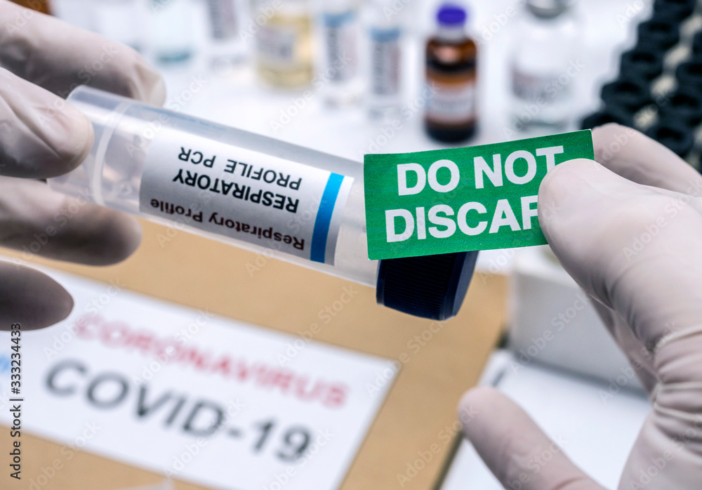 Nurse sticks label indicating not to discard from a covid-19 patient ...