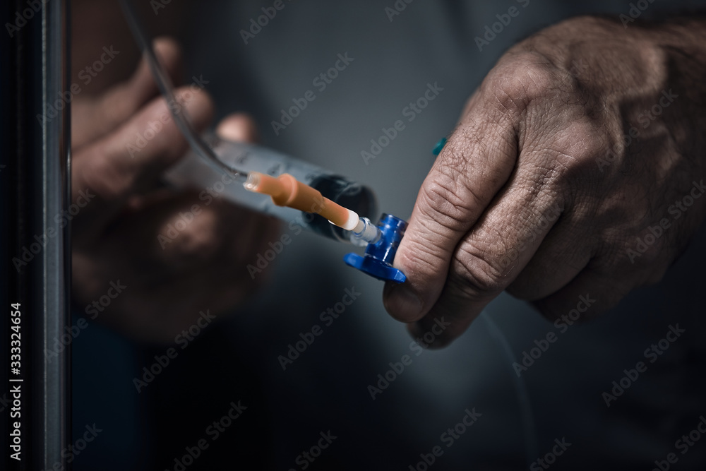 Hands of the doctor make an injection in a dropper. Dramatic scene ...