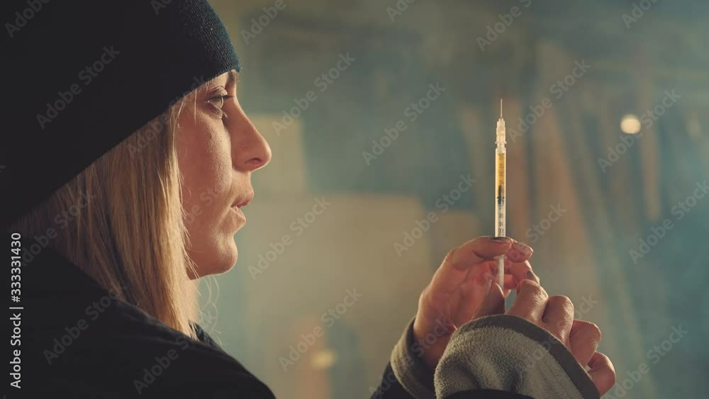 Addict woman with syringe in an abandoned house. Drug use, addiction ...