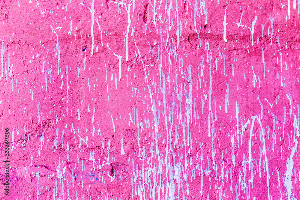 Pink painted wall withleaks of light paint. Drops of white paint flow ...