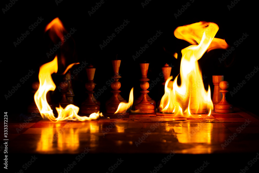 chess board on fire with figures in the dark, front and background ...