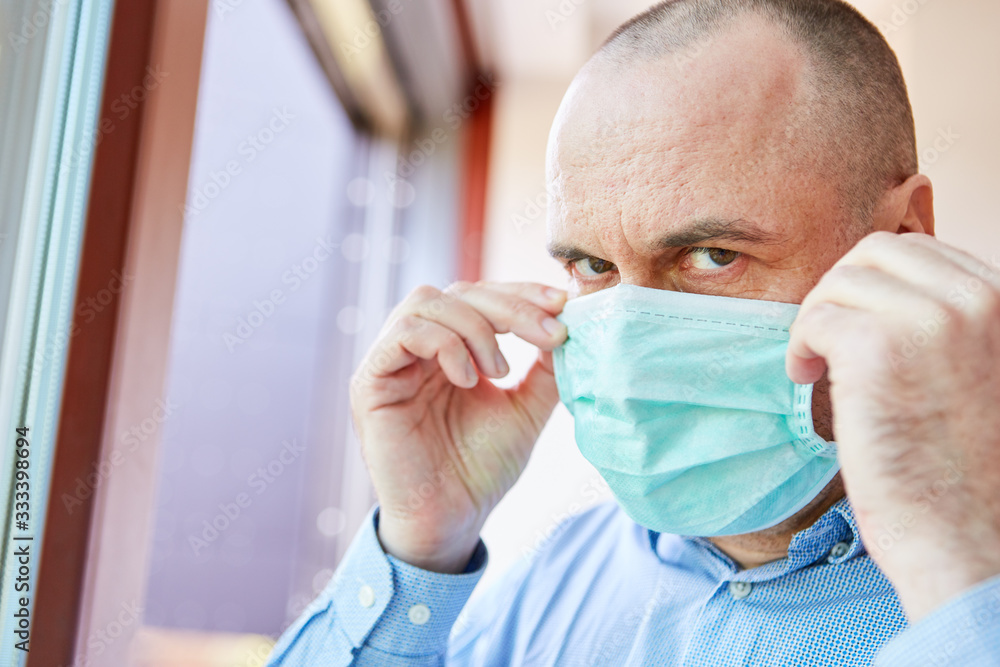 Man in quarantine as a Covid-19 patient with a face mask Stock Photo ...