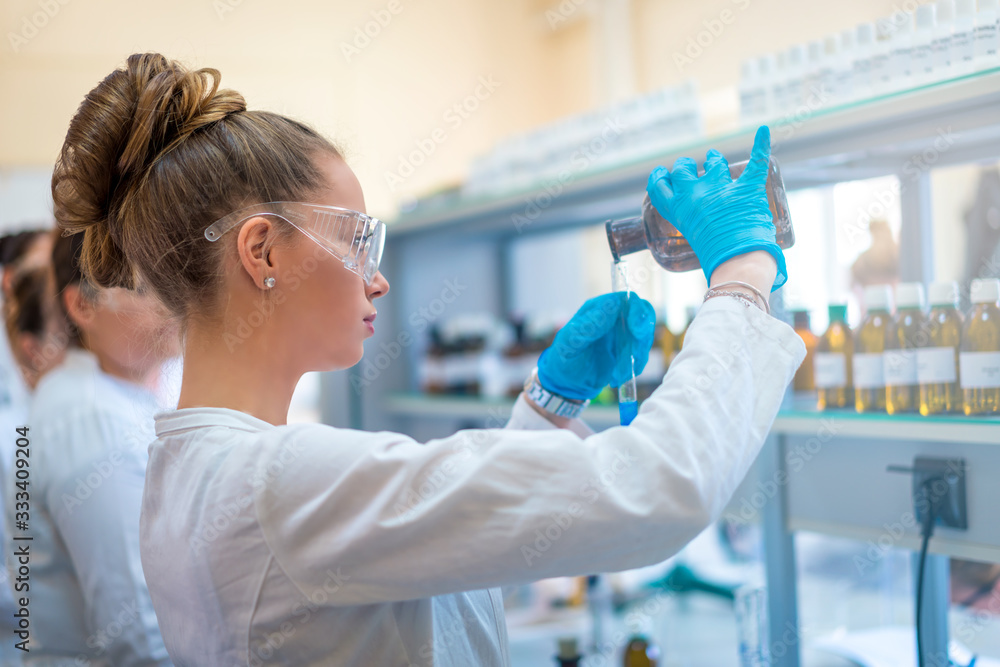 Beautiful young woman scientist in laboratory working. Young female ...