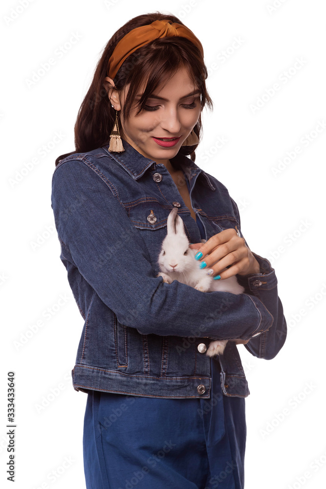 Beautiful brunette woman holding a white, fluffy rabbit. A pet. Wearing ...