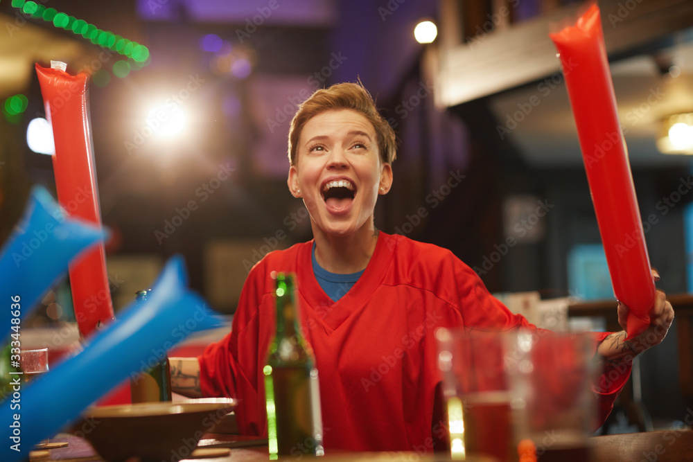 Young excited woman in red shirt cheering for football team in sport ...