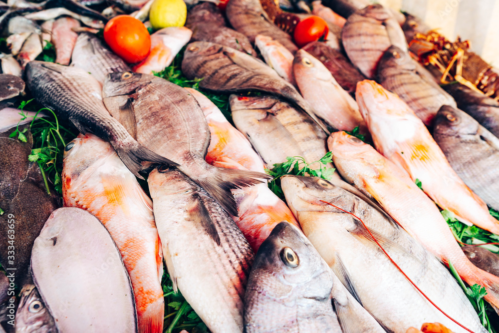 Different types of fresh sea fish on a market table. Stock Photo ...