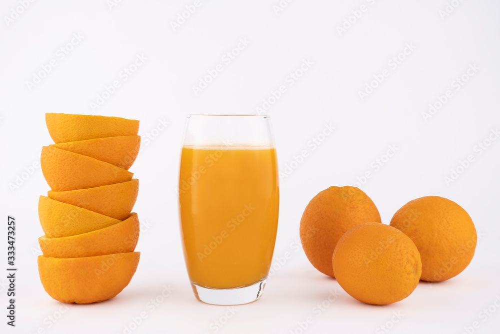 Squeezed oranges' peels and a glass of orange juice on white background ...
