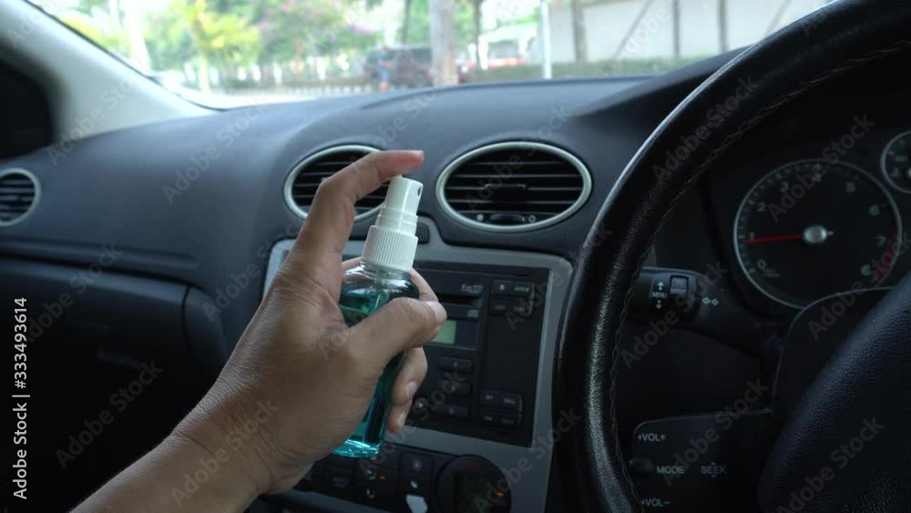 Hand of man is spraying alcohol,disinfectant spray in his car,prevent ...