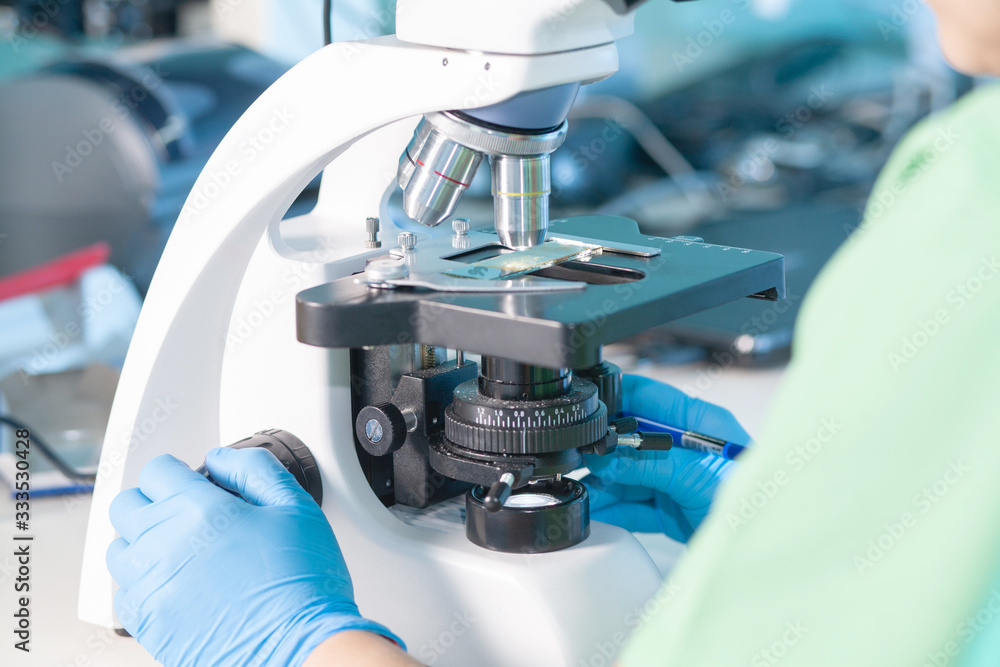 Female professional in uniform, hands in gloves. Working with light or ...