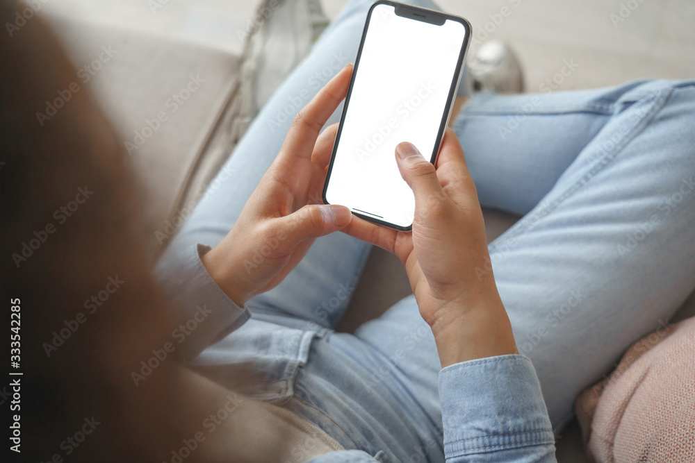 Young woman user customer hold smart phone mock up white screen in hand ...