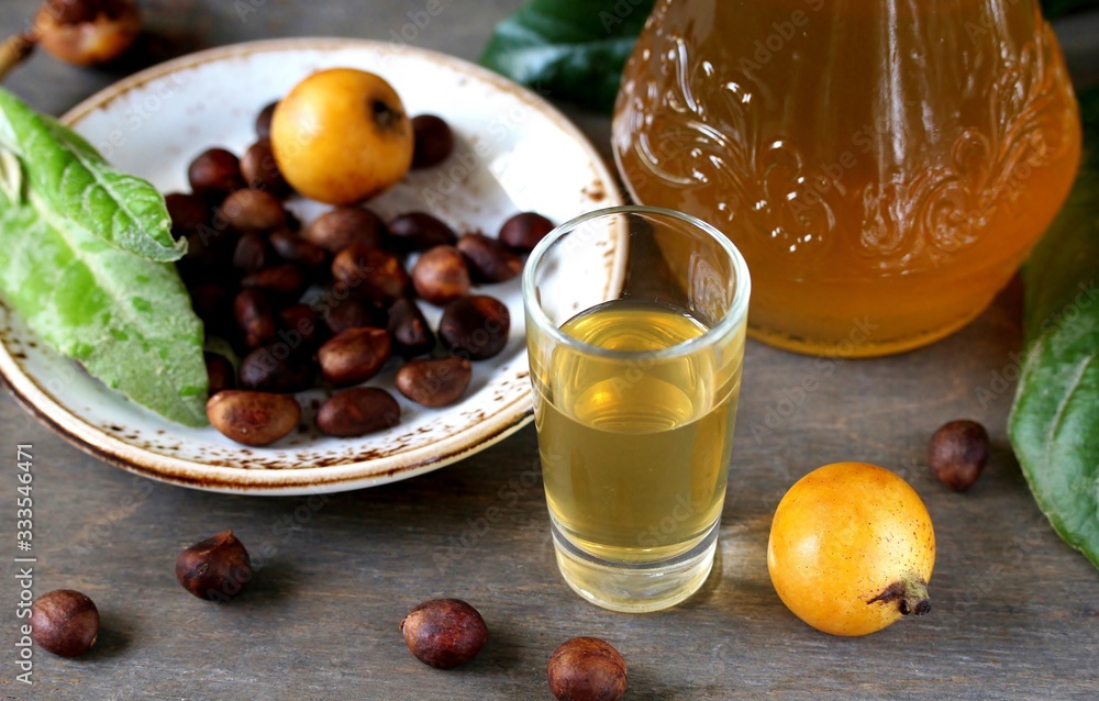 Liqueur nespolino. Loquat seed liquor. tincture alcoholic on bones ...