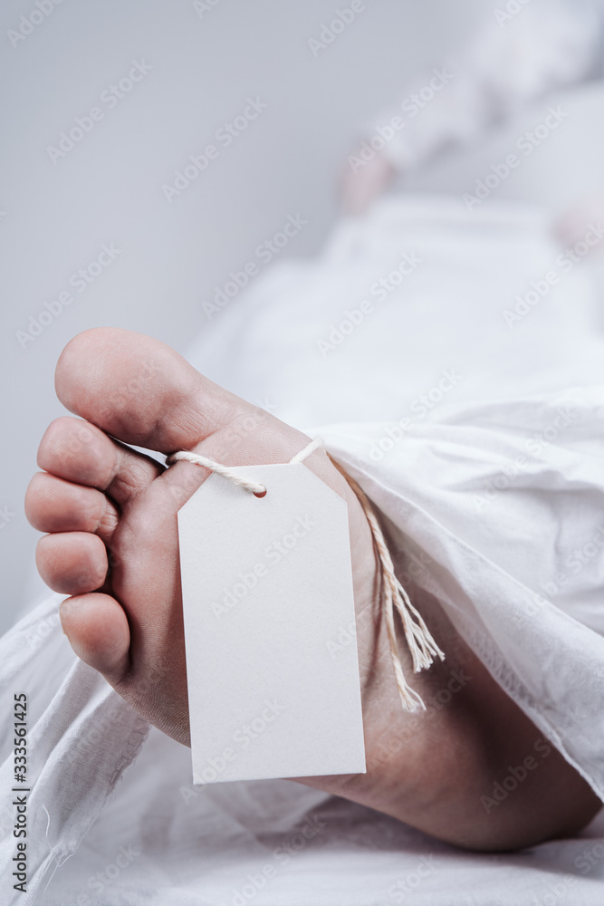 Feet of a dead body, with an identification tag - blank sign attached ...