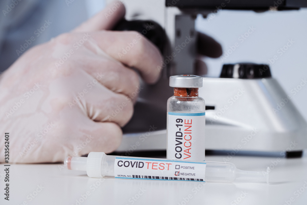 Microbiologist examines the sample under a microscope. Coronavirus ...