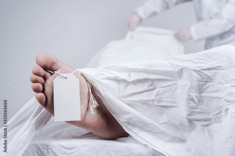 Feet of a dead body, with an identification tag - blank sign attached ...