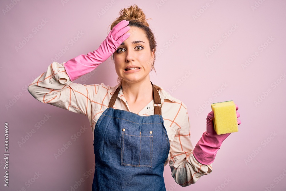 Beautiful blonde cleaner woman doing housework wearing arpon and gloves ...