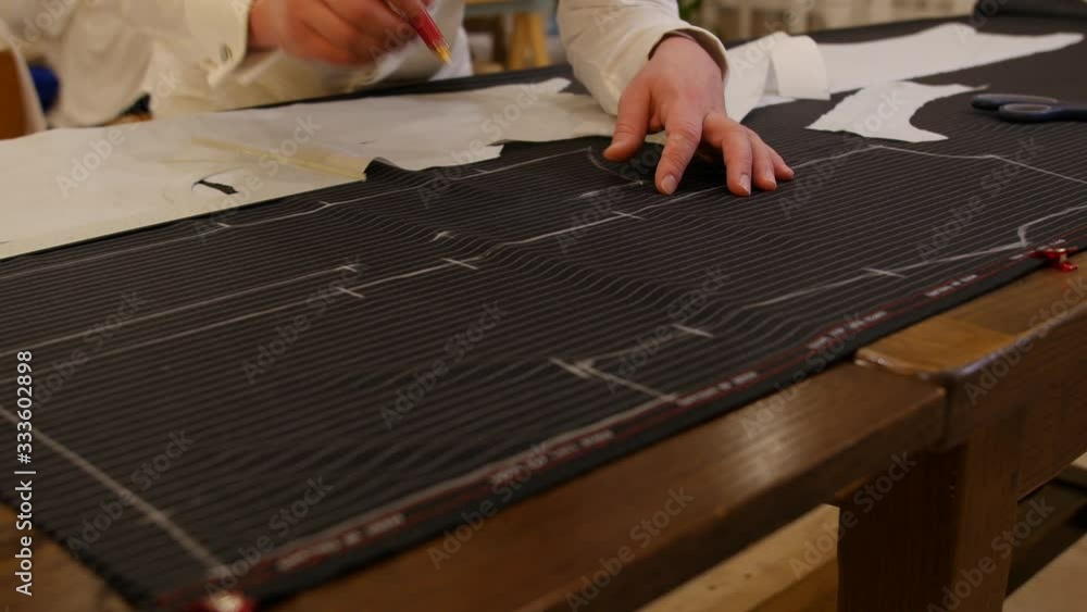 Hands of male tailor drawing pattern in studio. man's hand draws with ...
