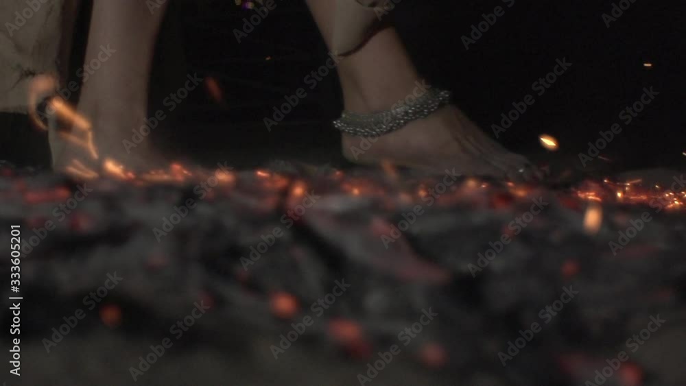 Woman with bare feet resolutely walks over hot coals. Brave woman with ...