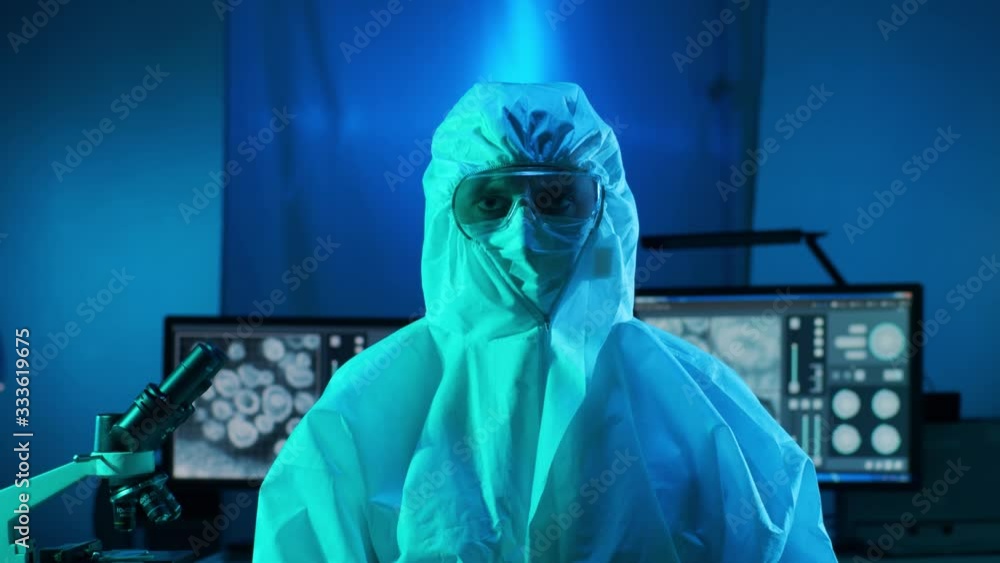 Scientist in protection suit and masks working in research lab using ...