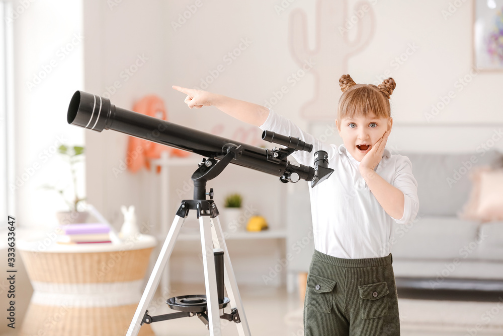 Cute surprised little girl with telescope at home Stock Photo | Adobe Stock