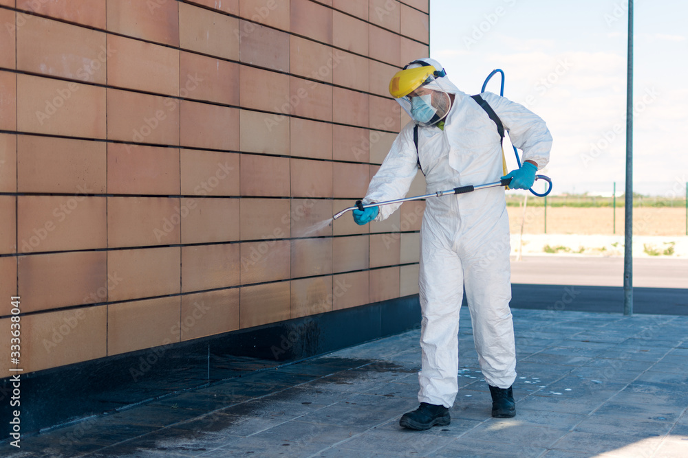 Man wearing an NBC personal protective equipment (ppe) suit, gloves ...