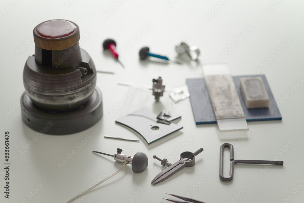 Various engraver goldsmith tools and object on white desk. Professional ...