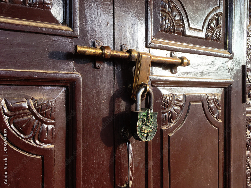 Closed entrance. Padlock locked on wooden door which is designed by ...