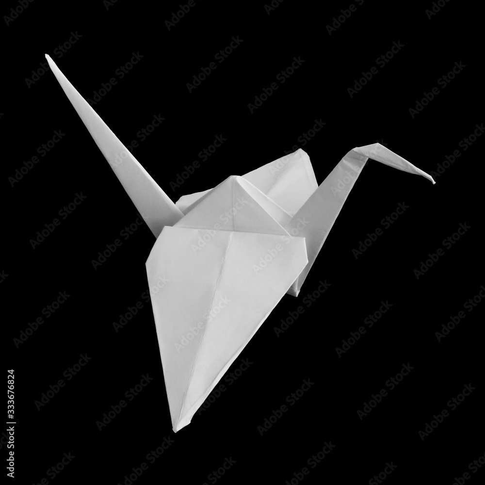Handmade white origami paper crane (or orizuru) isolated on the black ...