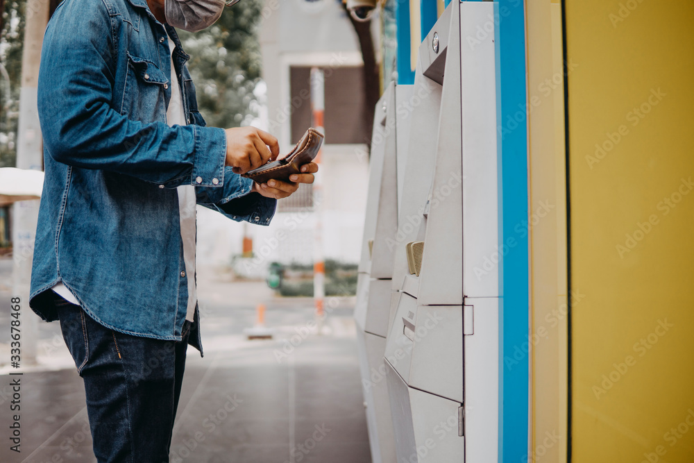 Young asian man wearing medical mask withdraw money from bank cash ...