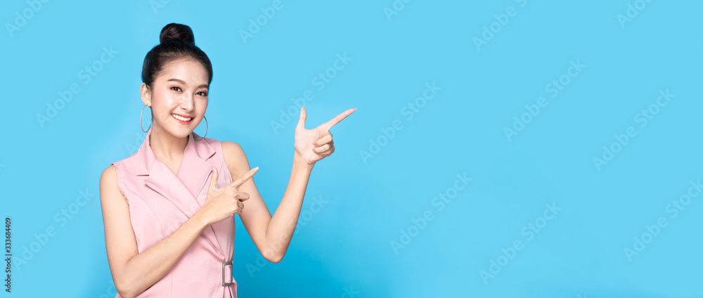 Portrait of Asian beautiful young woman pointing both hands with finger ...