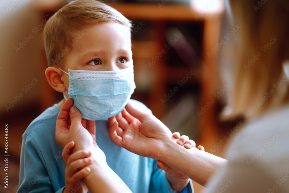 Little boy and mom in medical mask. Mother puts on her baby sterile ...