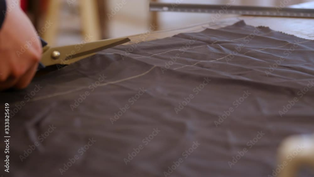 Fashion designer hands cutting lining with shears. Linings provide a ...