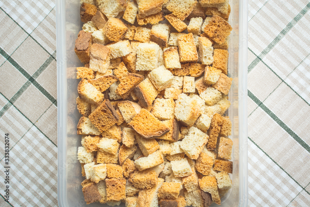Baked sliced white bread rusks in white container on kitchen table ...