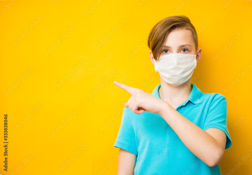 Young teen boy wearing health mask shows the index finger up against ...