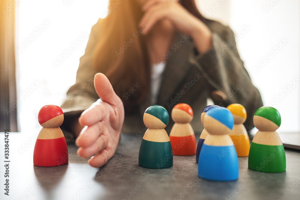 Concept image of a business woman separate wooden people into two group ...