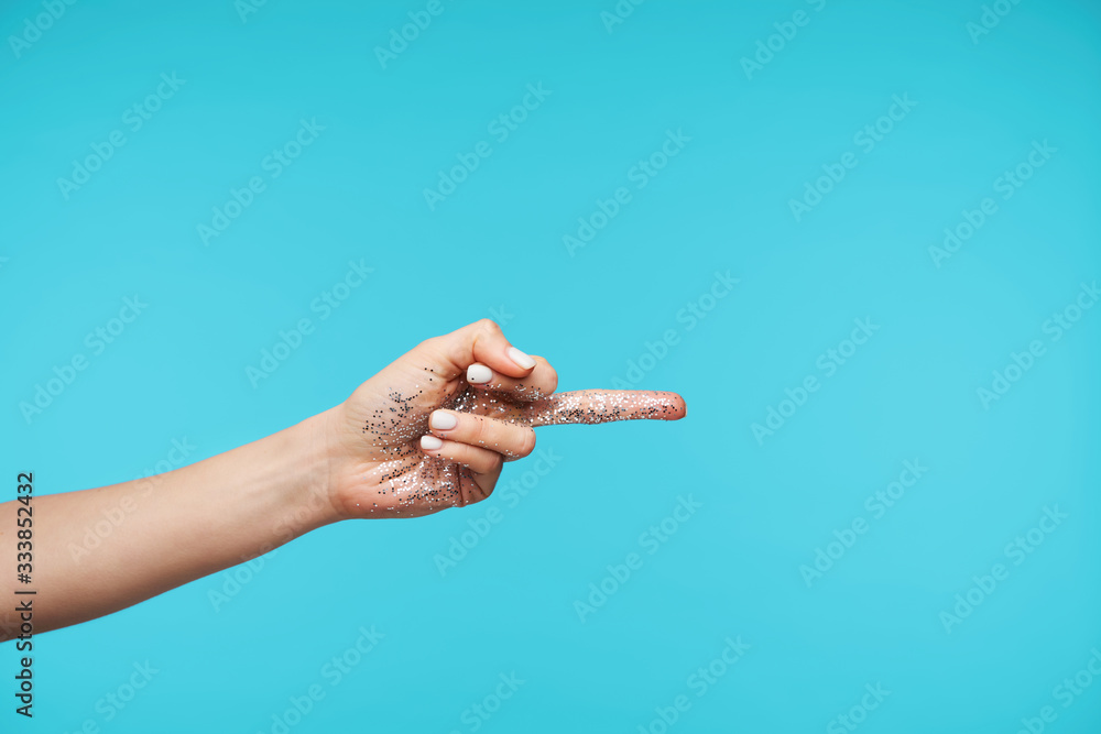 Beautiful young woman's hand with glitter being raised up while ...