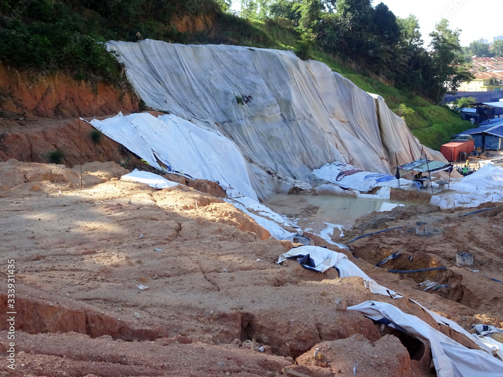 The geotextile fabric is spread over the surface of the slope to ...