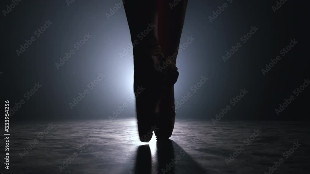 Close up of ballet dancer's feet in pointe warmed up before performing ...