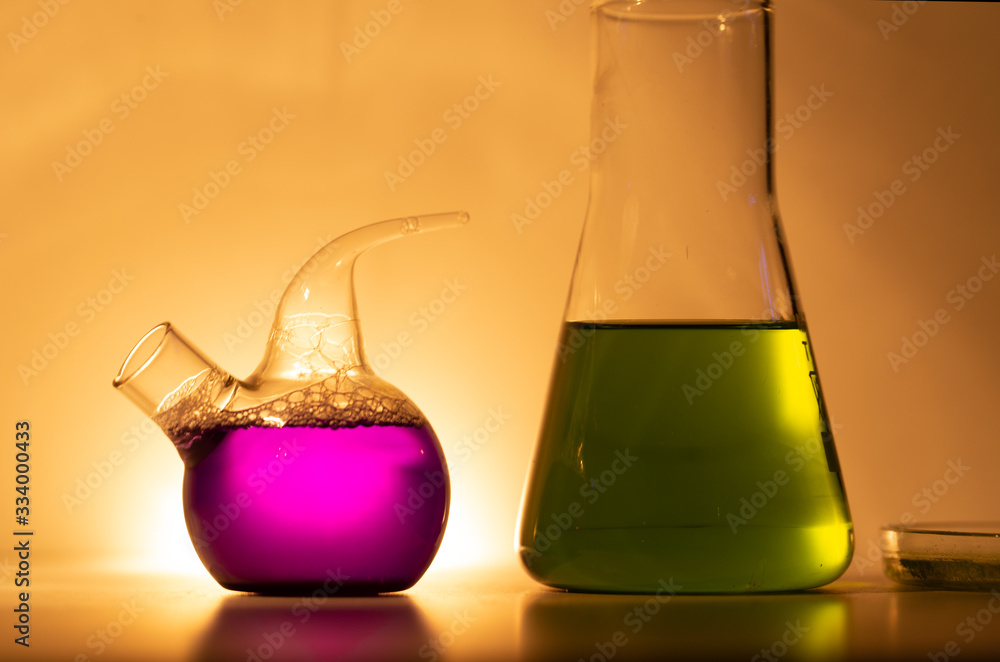 Beaker and retort with green and blue chemical reagent. Chemical ...