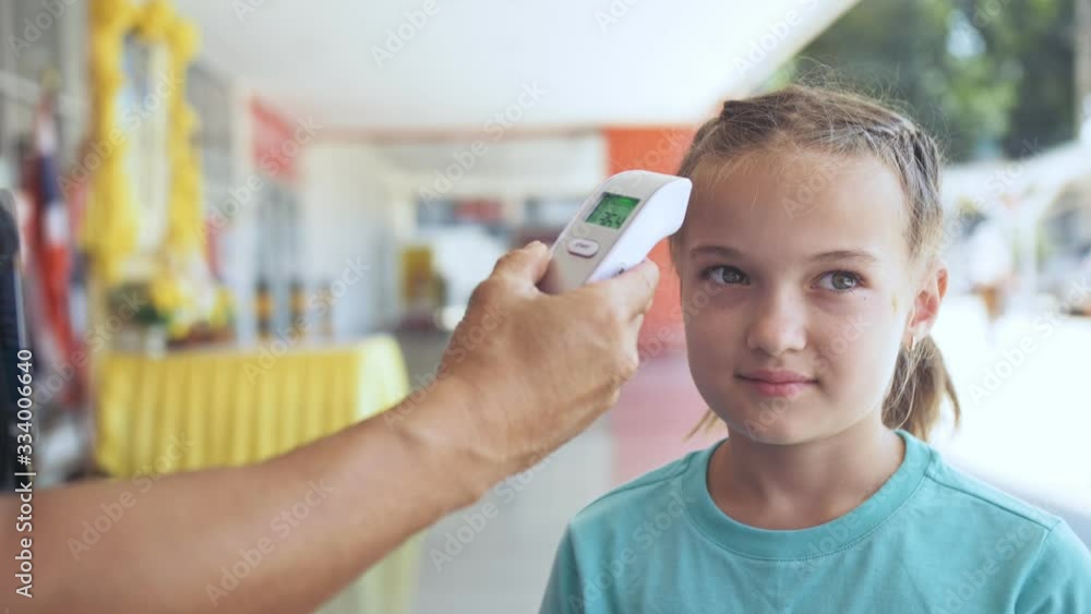 Temperature check at a supermarket of little girl, grocery store with ...