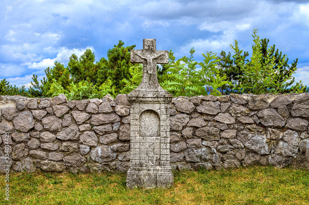 Ancient aged grave-stone with crucifix afore medieval wall. Old ...