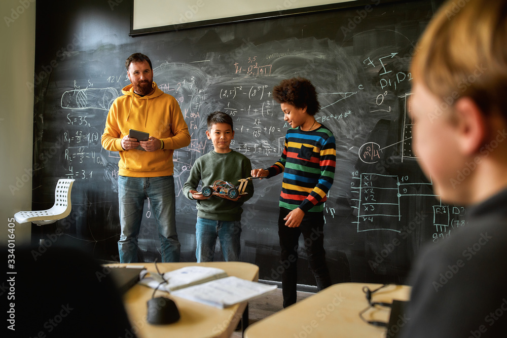 A Quality School. Young male science teacher standing near the ...