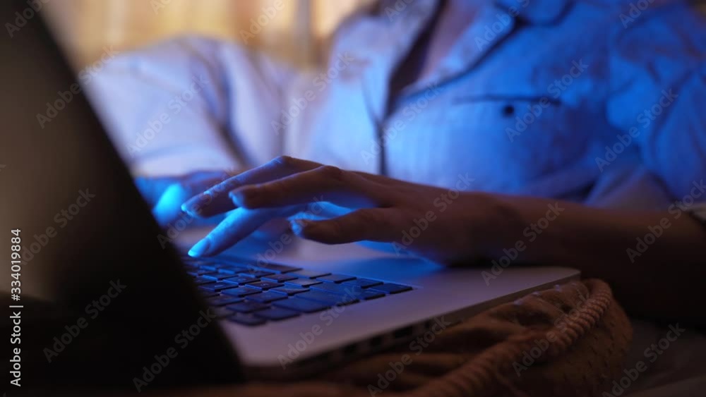 This close up video shows the hands of someone in pajamas working at ...