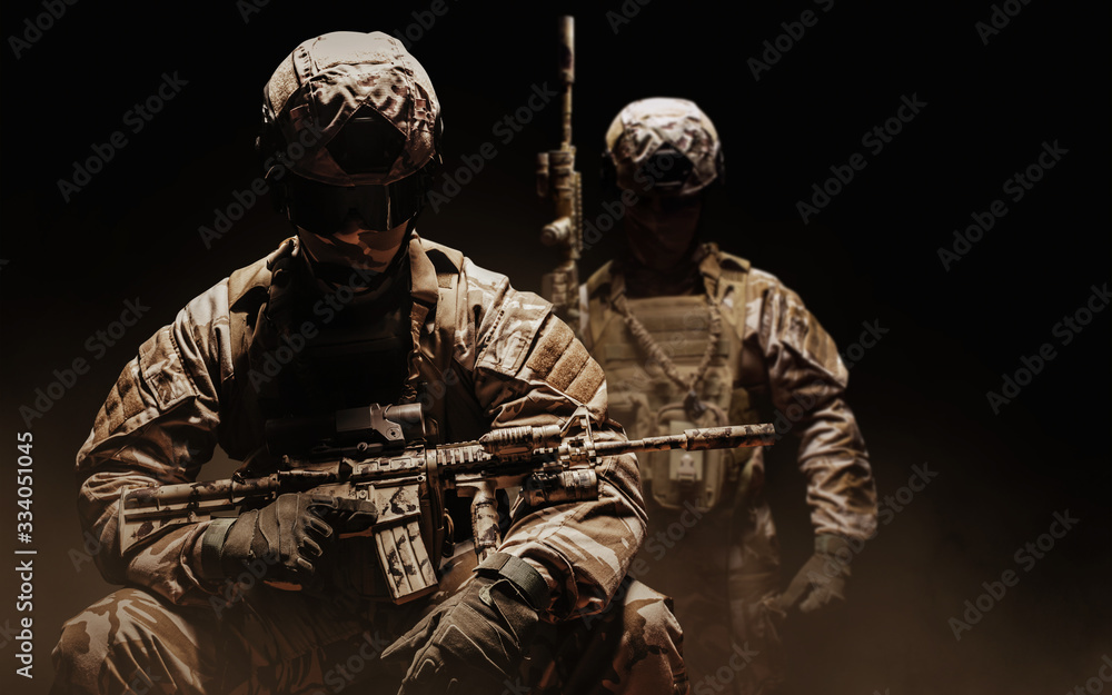 Soldiers in uniform sitting and standing with rifle Stock Photo | Adobe ...