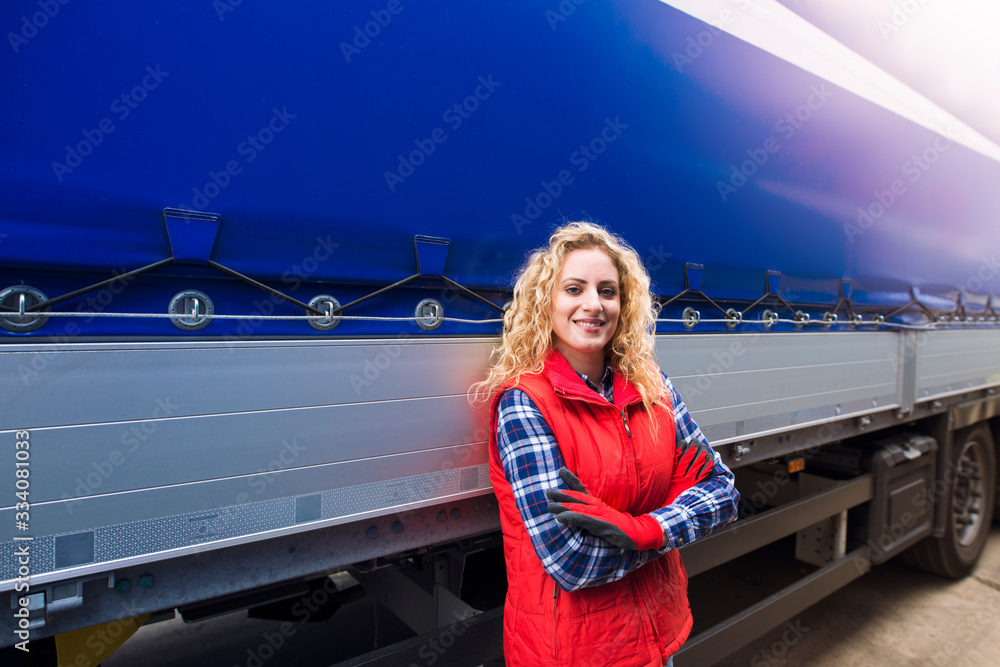 Portrait of female trucker with crossed arm proudly standing by her ...