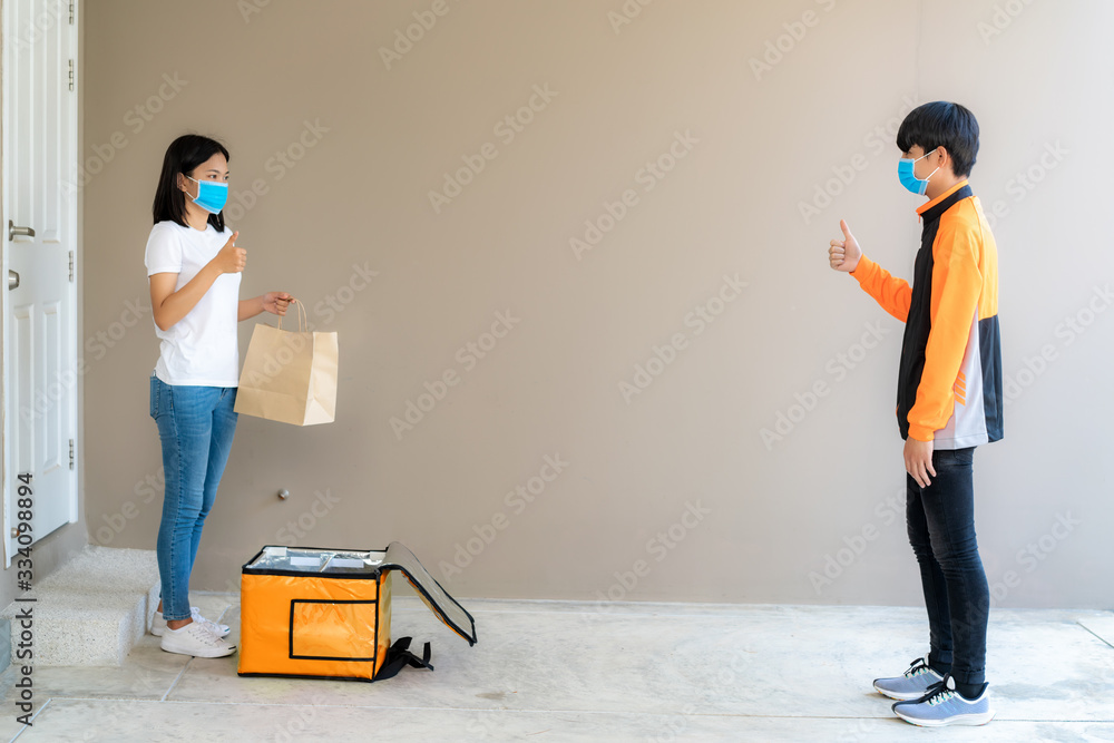 Asian woman pick up delivery food bag from box and thumb up form ...