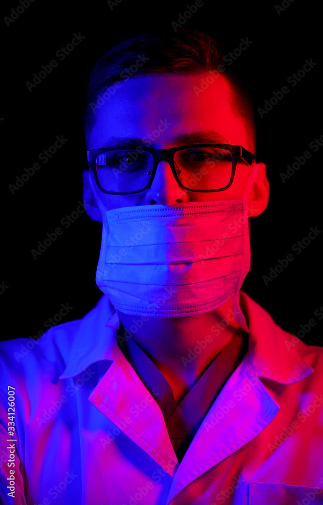 Doctor wears mask. Black background with blue - red light. Doctor in ...