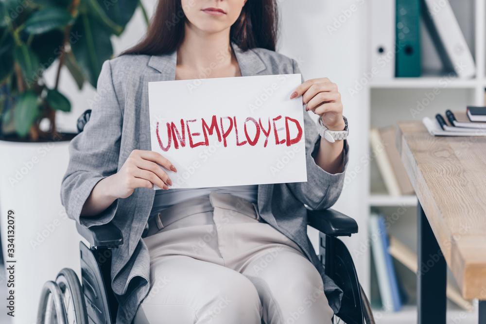 Cropped view of disabled employee holding placard with unemployed ...